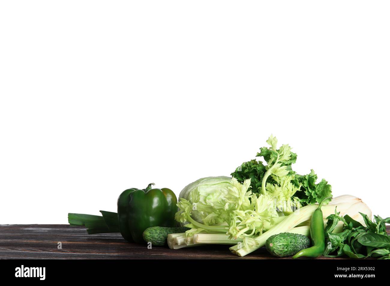 Fresh vegetables on brown wooden kitchen table against white background ...