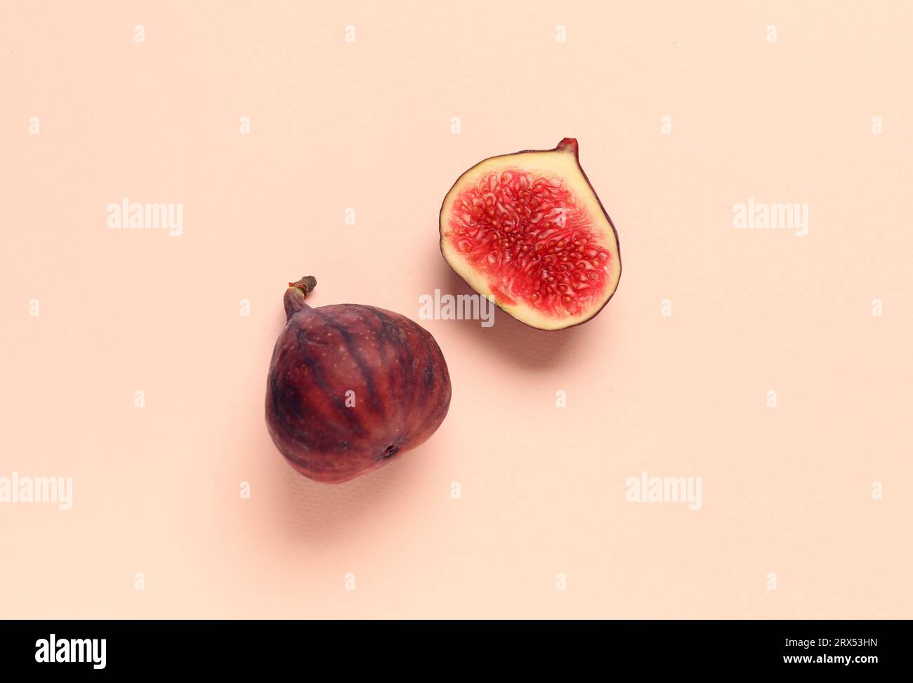 Fresh juicy cut figs with on pale pink background Stock Photo - Alamy