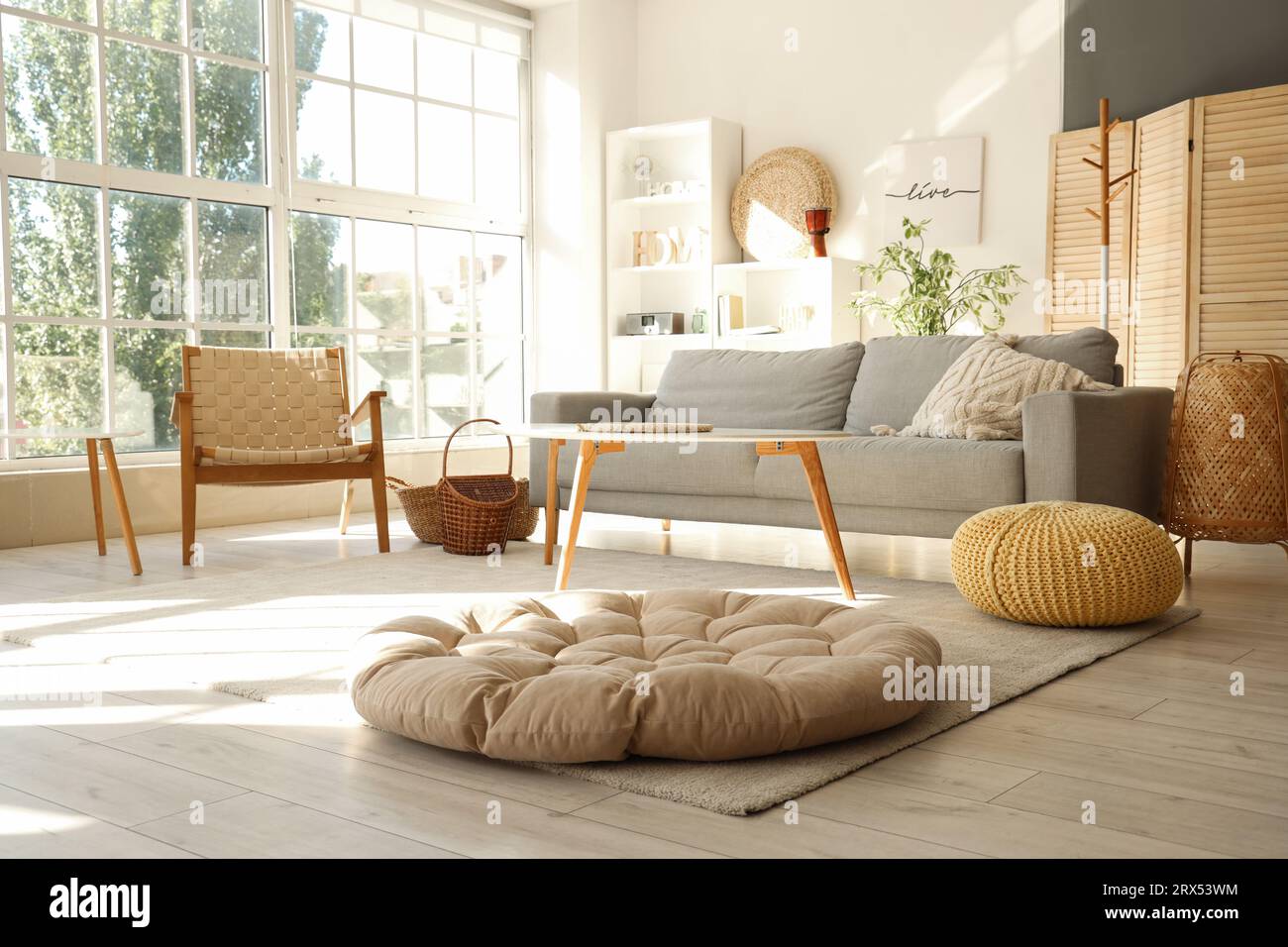 Interior of living room with sofa, table and poufs Stock Photo - Alamy