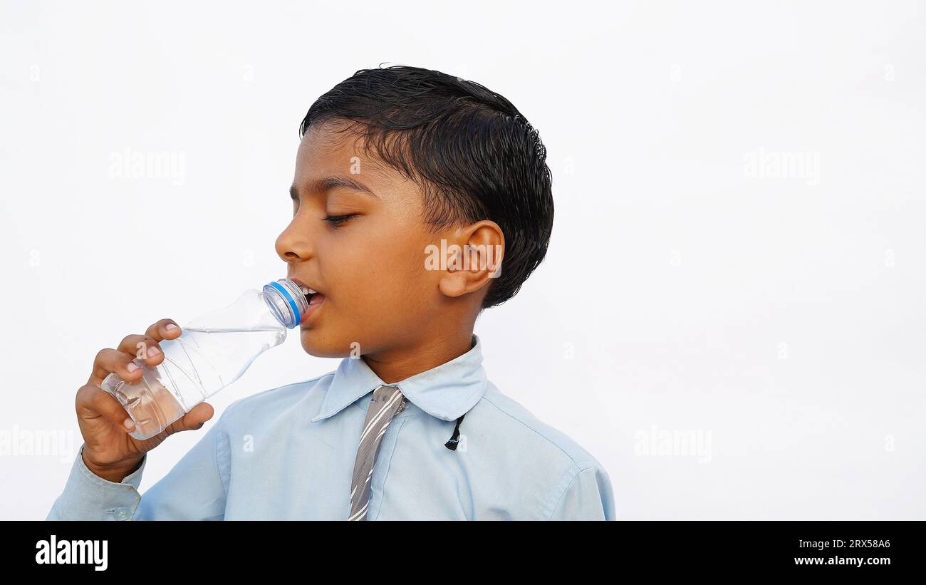 Asian school kids drink water from a bottle against the studio ...