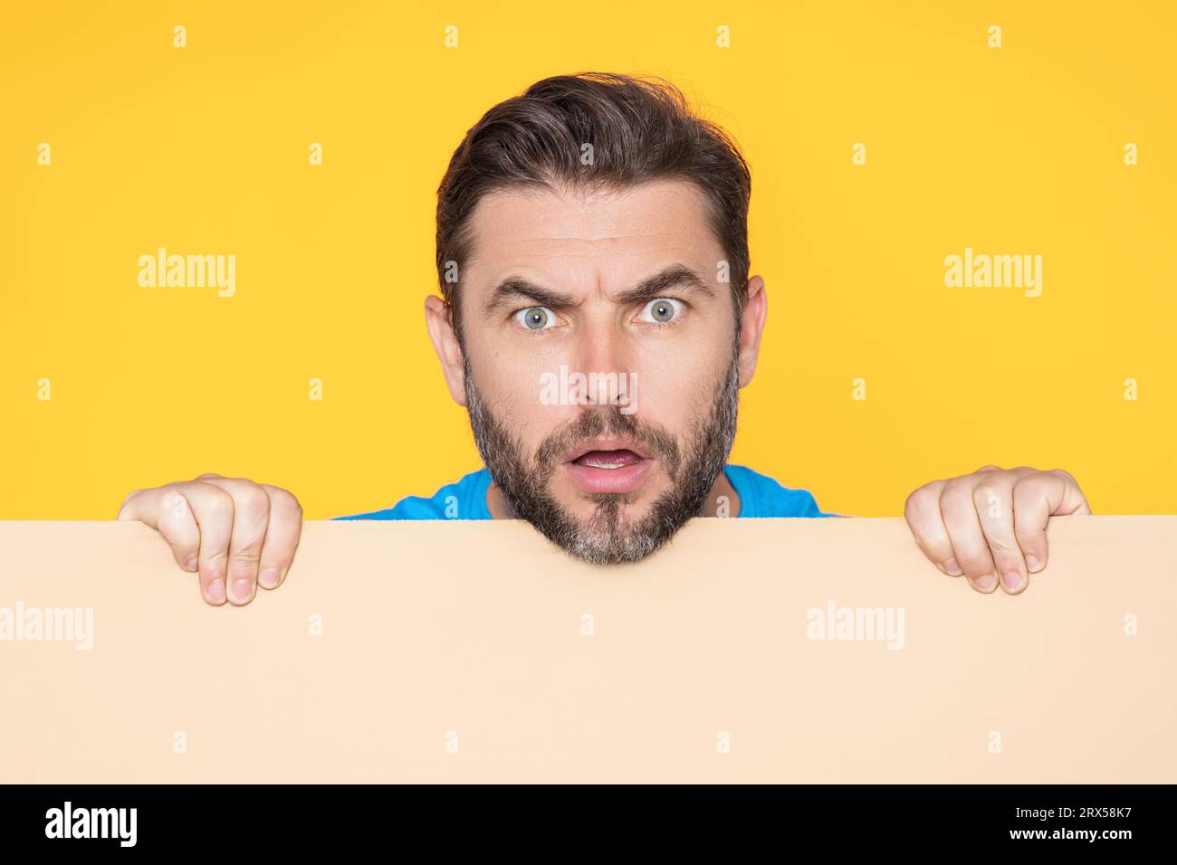 Angry man face with empty board on studio background. Anger guy showing ...