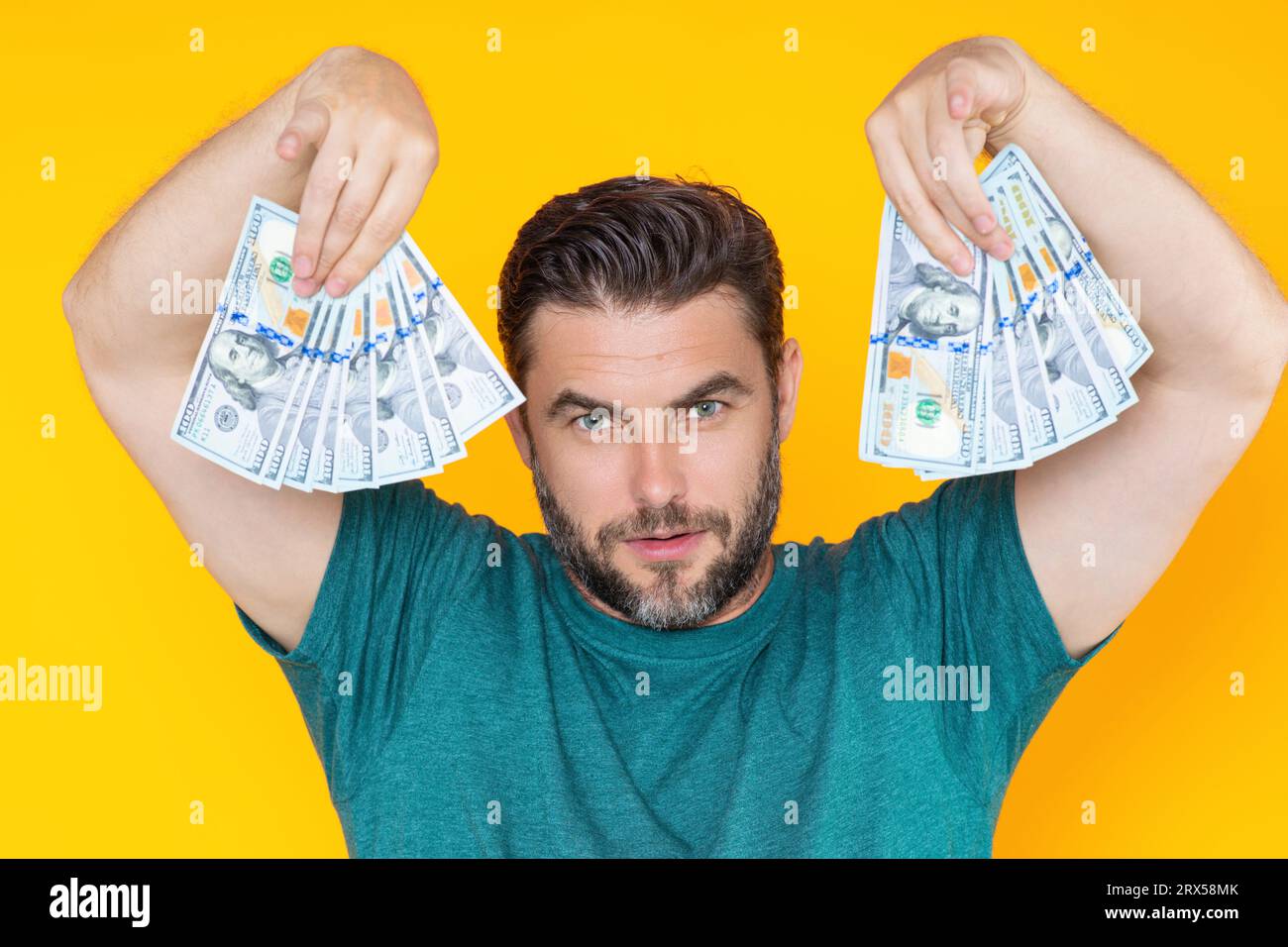 Man holding cash money in dollar banknotes on isolated yellow ...