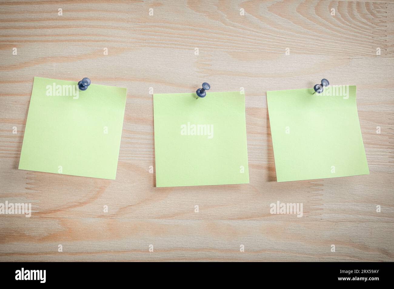 Three green paper notes mockup pinned to wooden bulletin board. sticky ...