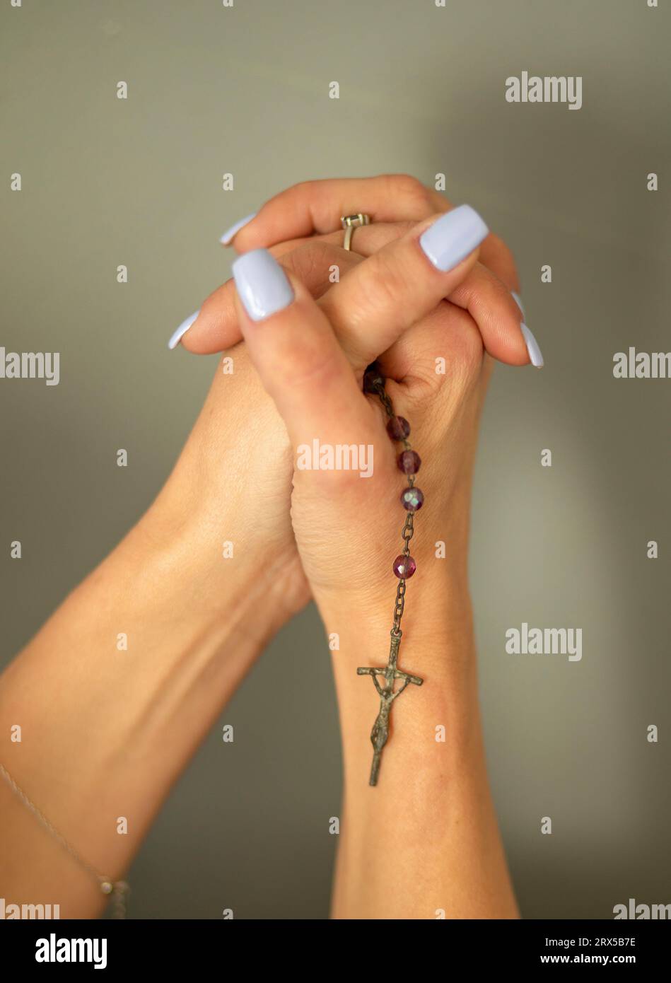 Women's hands holding a rosary, praying Stock Photo - Alamy