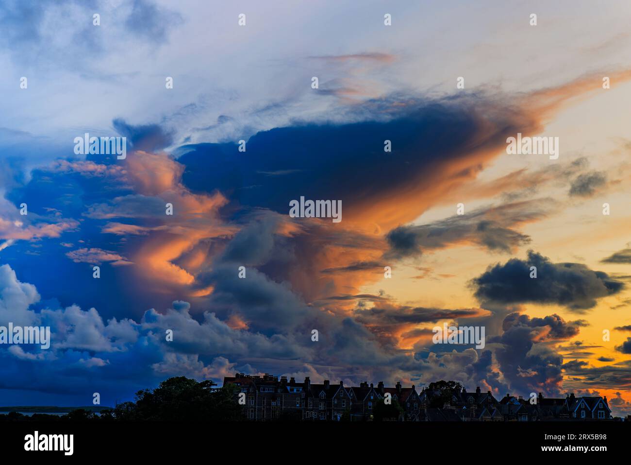 The setting sun lighting up the cloud cover over Clevedon Stock Photo ...