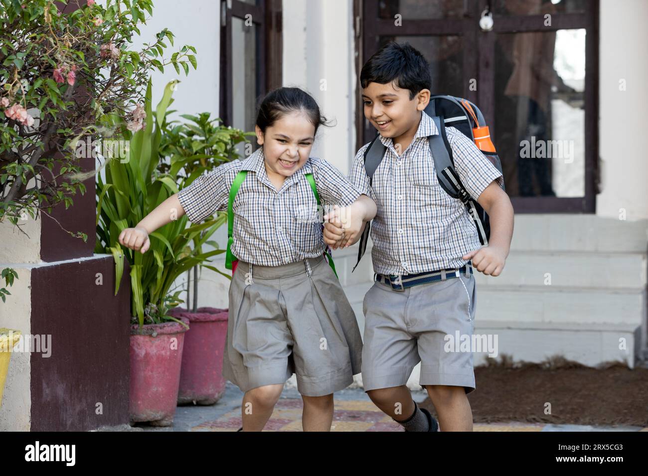 Happy indian school kids student holding hands running outside the ...