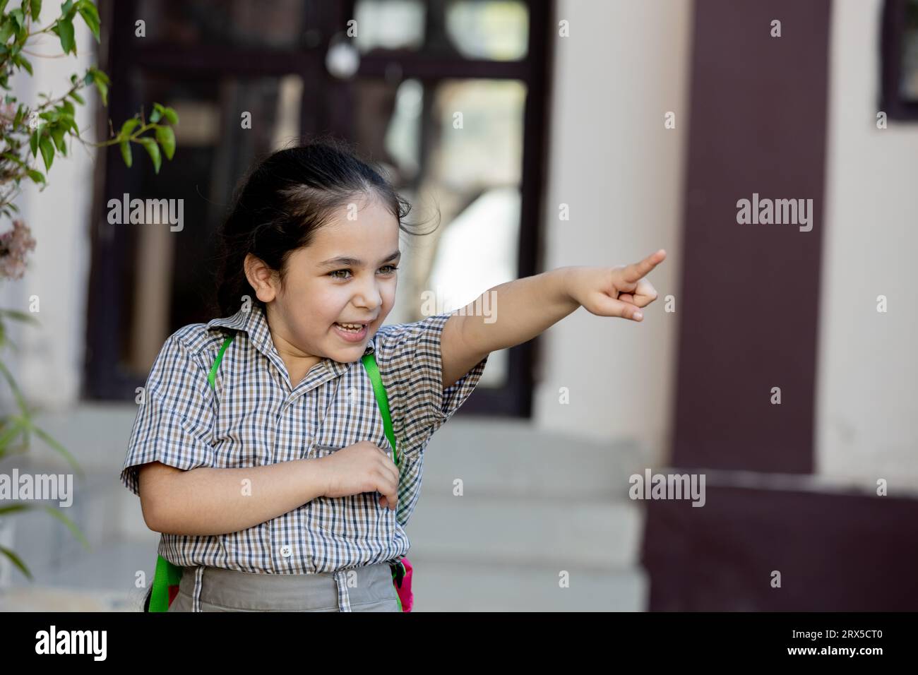 Happy indian school girl student pointing at something outside the ...
