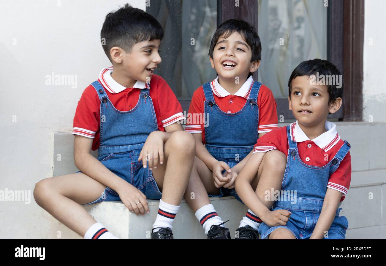 Happy indian boys student sitting together outside the school and ...