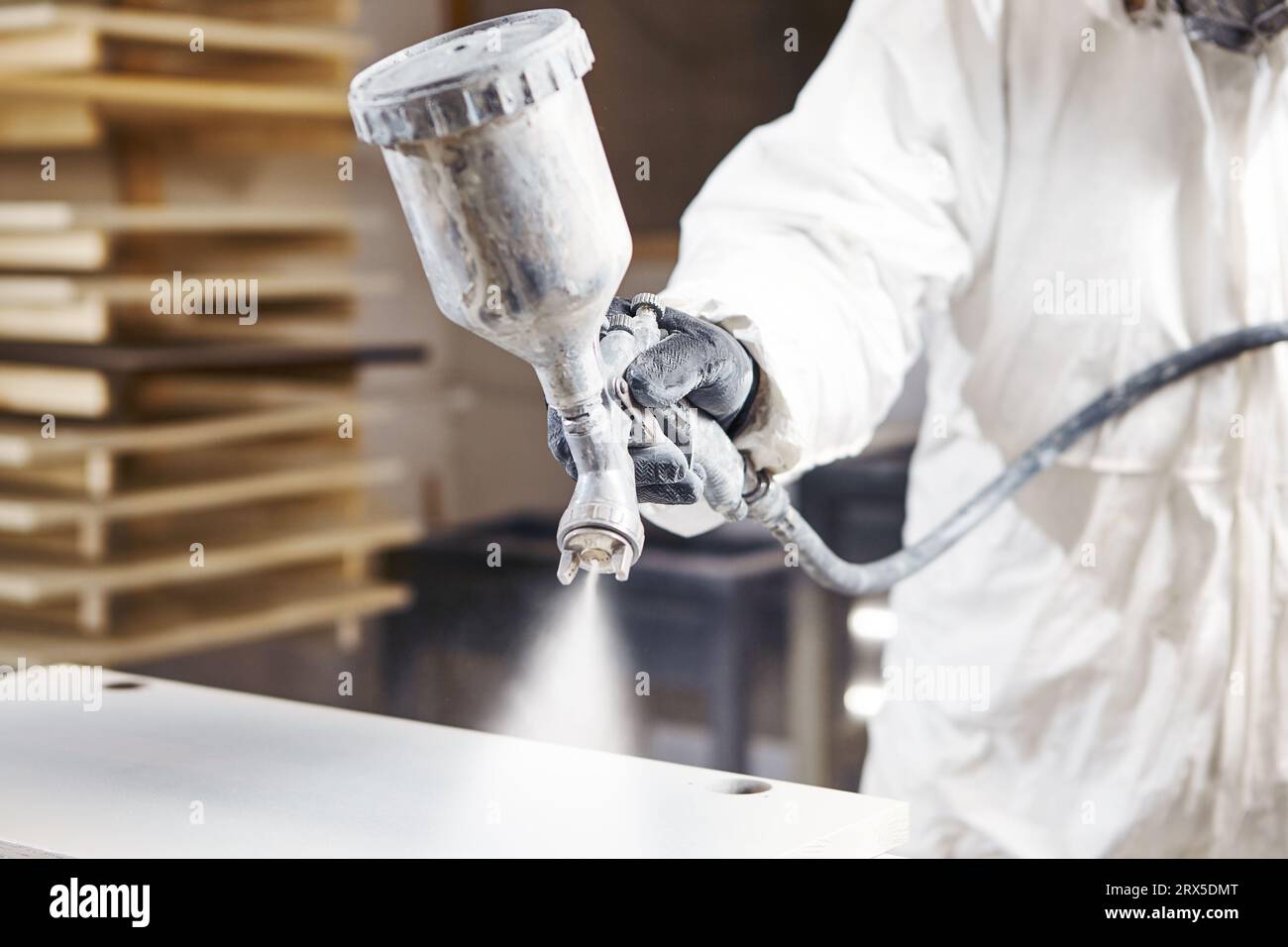 Close-up of industrial worker using paint gun or spray gun for applying ...