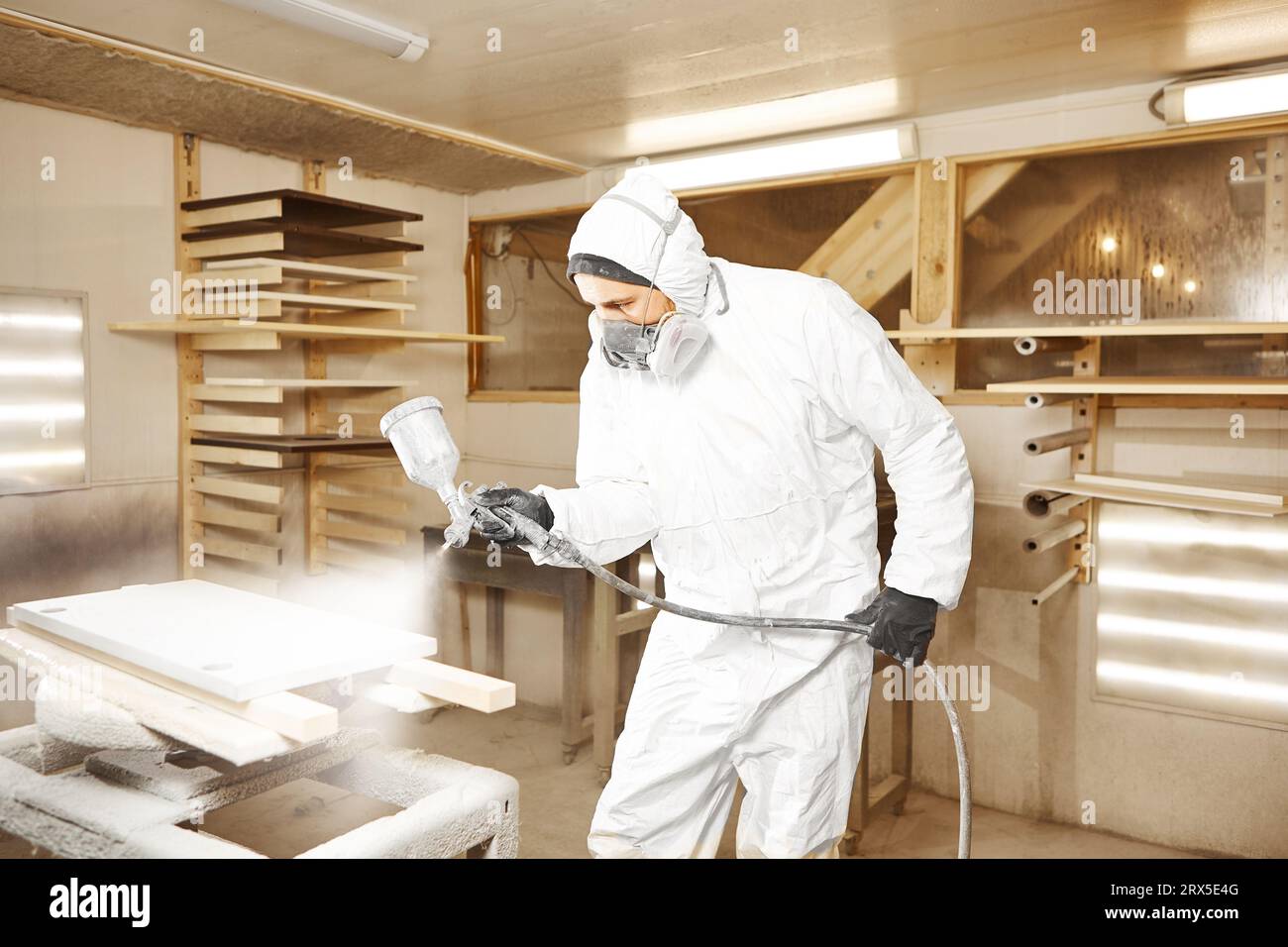Man working with paint spray gun, airless spraying to wood Stock Photo ...