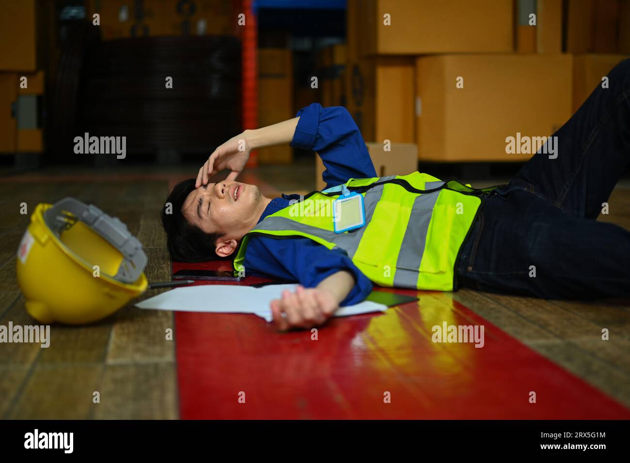 Asian male worker lying down on floor with injured head after accident ...
