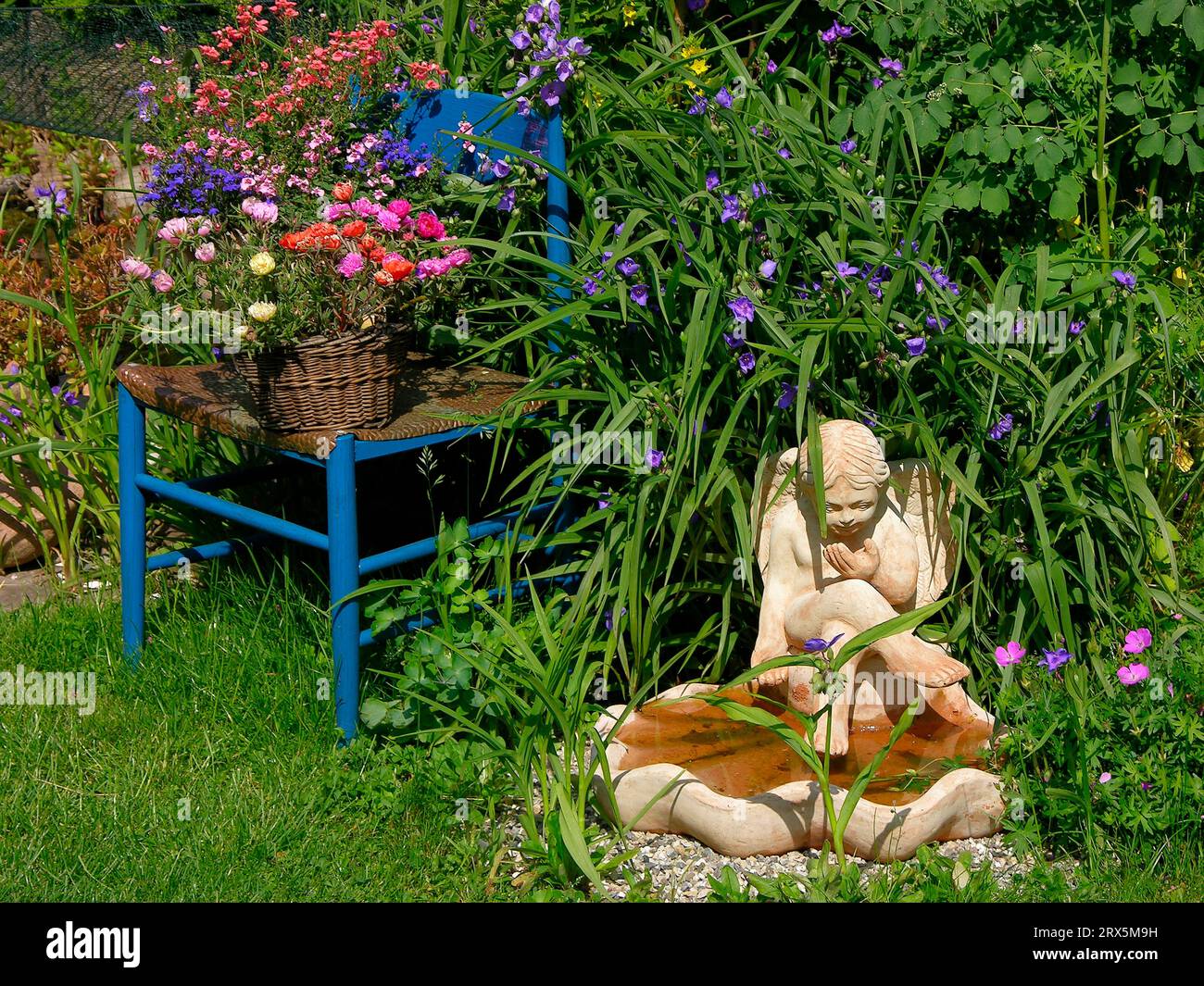 Garden figure with bird bath, potted plants on garden chair Stock Photo ...
