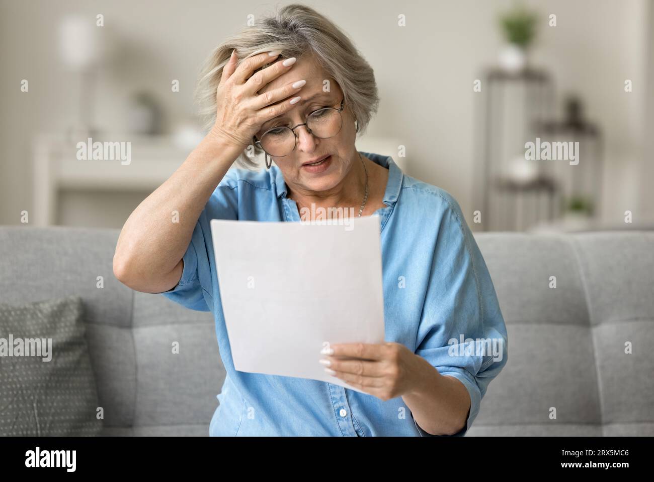 Stressed frustrated older woman getting bad news from paper letter ...