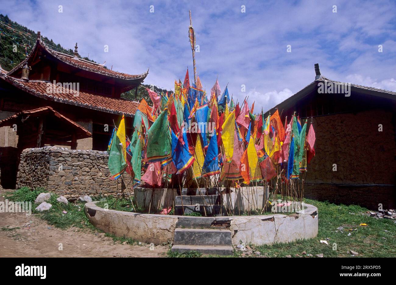 Tibetan prayer flags on a round pedestal in a mountain village, Sichuan ...