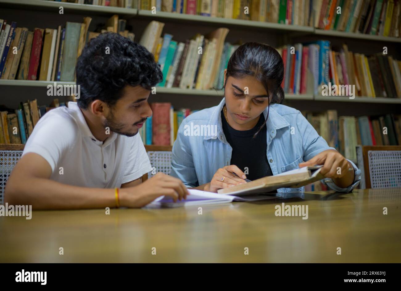 Young college students helping each other to study in the library Stock ...