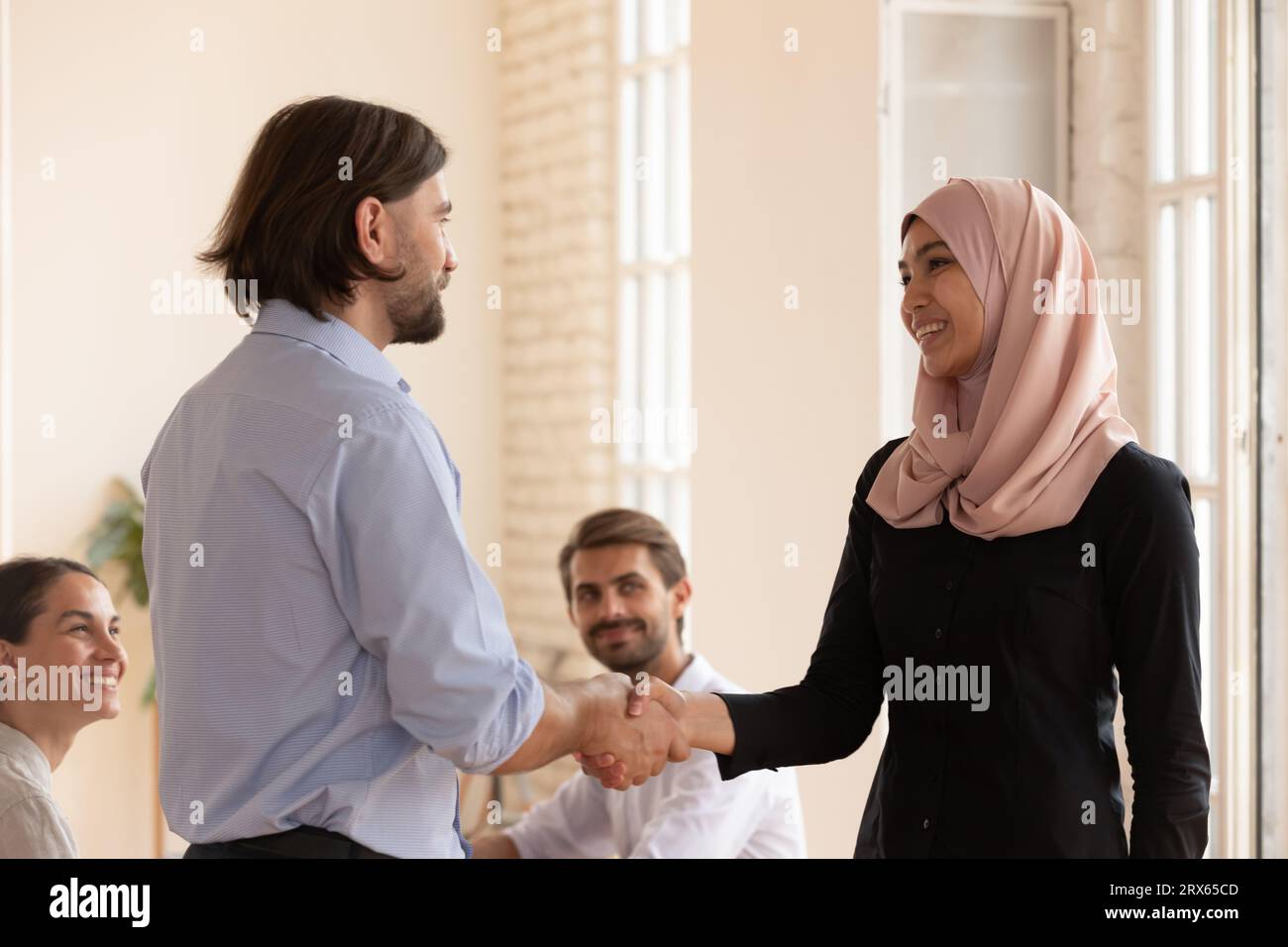 Arabian female in hijab worker handshake with boss receiving praises ...
