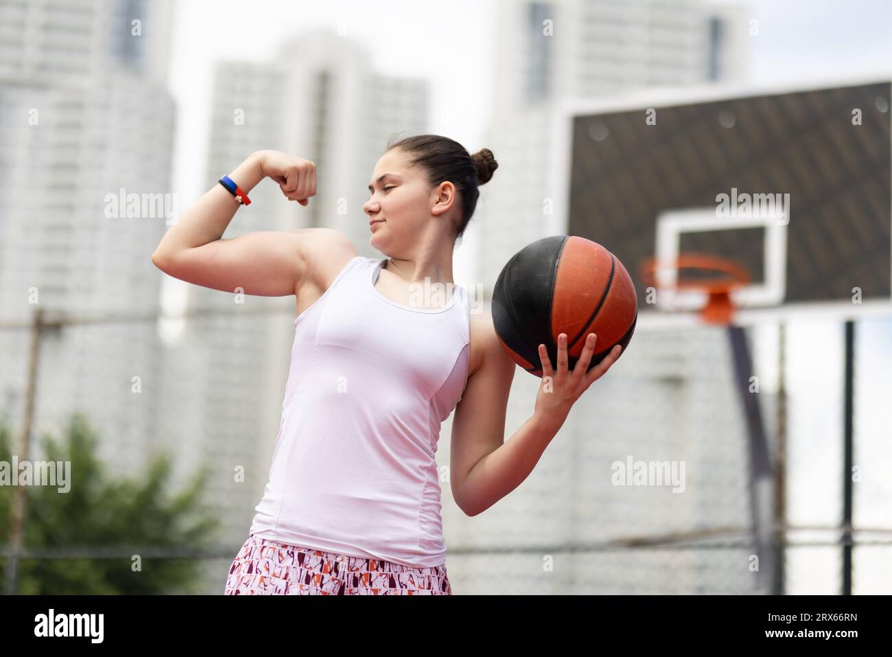 Basketball player portrait. Girl posing and showing muscles. Outdoor ...