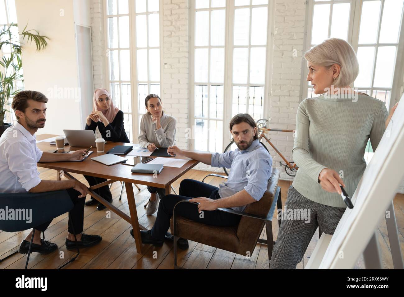 Diverse company staff members listen mature female business coach Stock ...