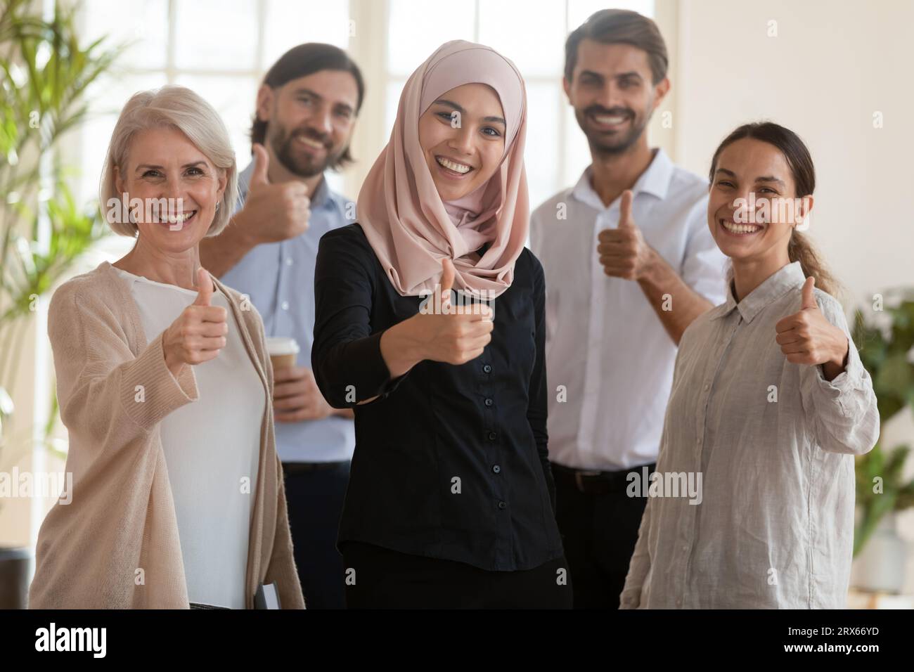 Arabian businesswoman leader and diverse staff smiling showing thumbs ...
