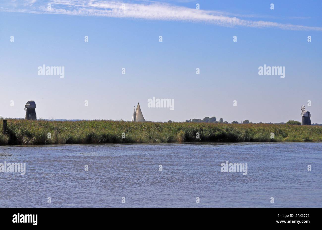 A yacht sail viewed on the meandering River Bure between two redundant ...