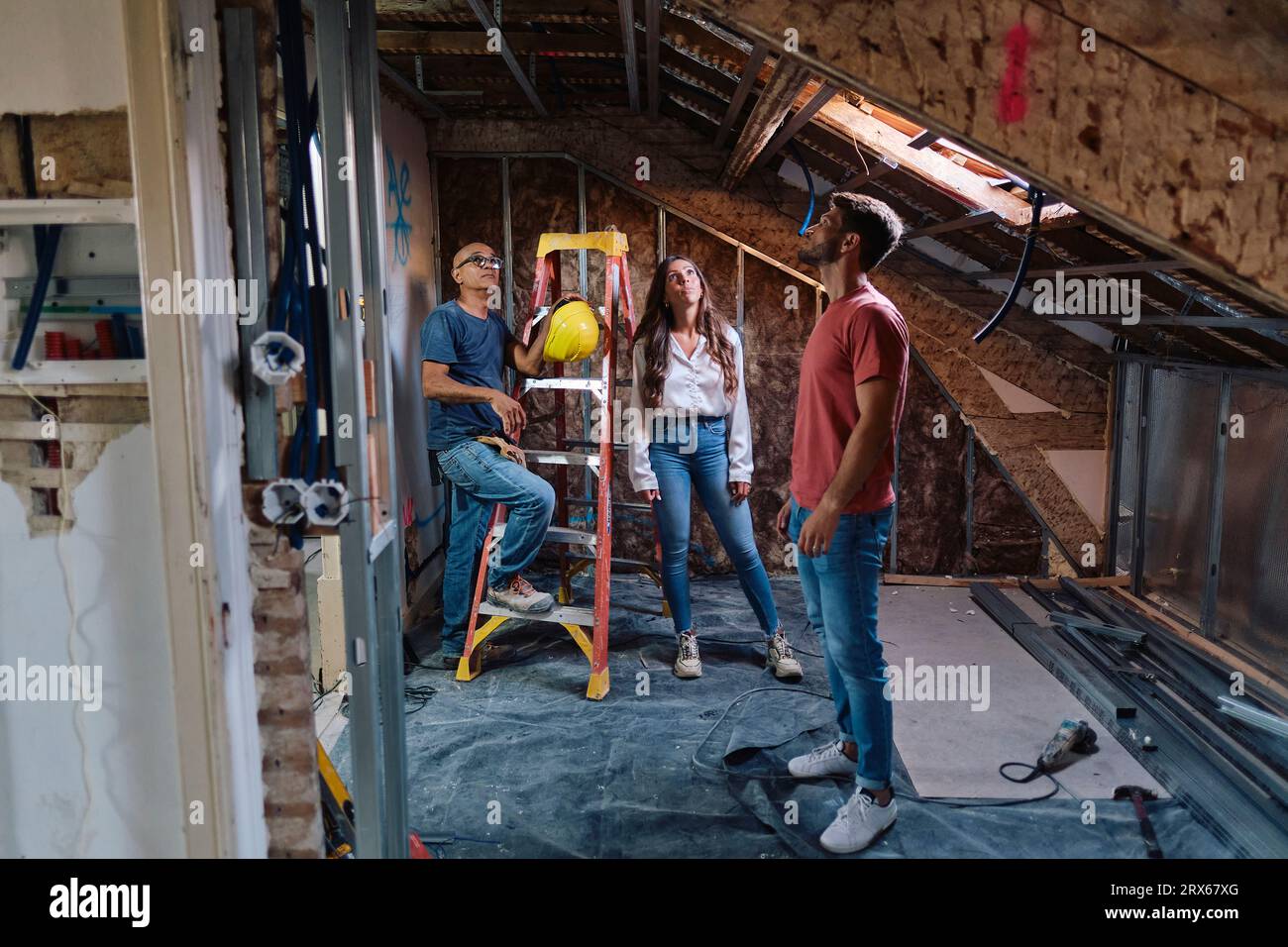 Man and woman having discussion with construction worker at ...