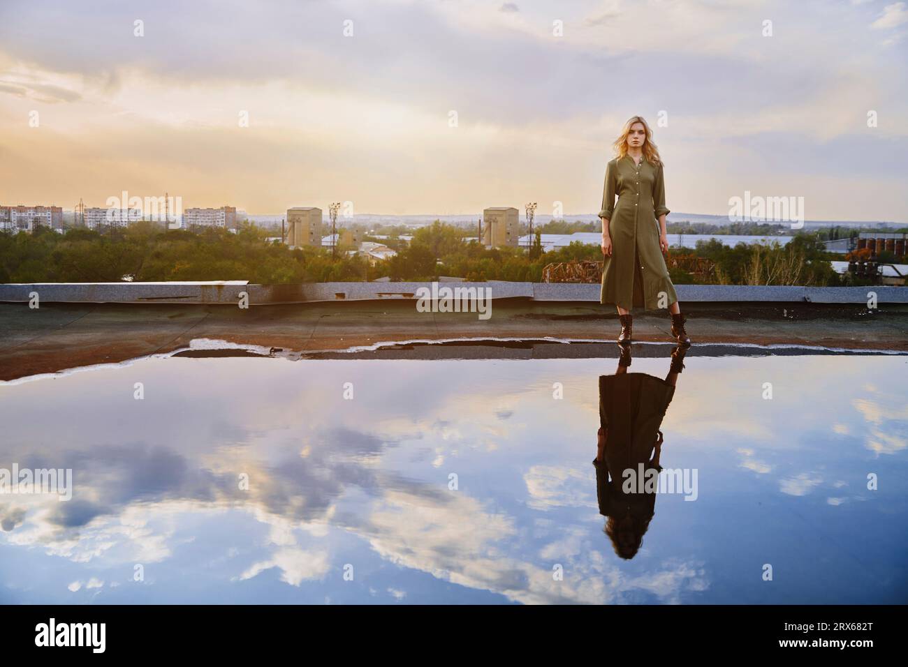 Woman reflecting in puddle standing on rooftop Stock Photo - Alamy