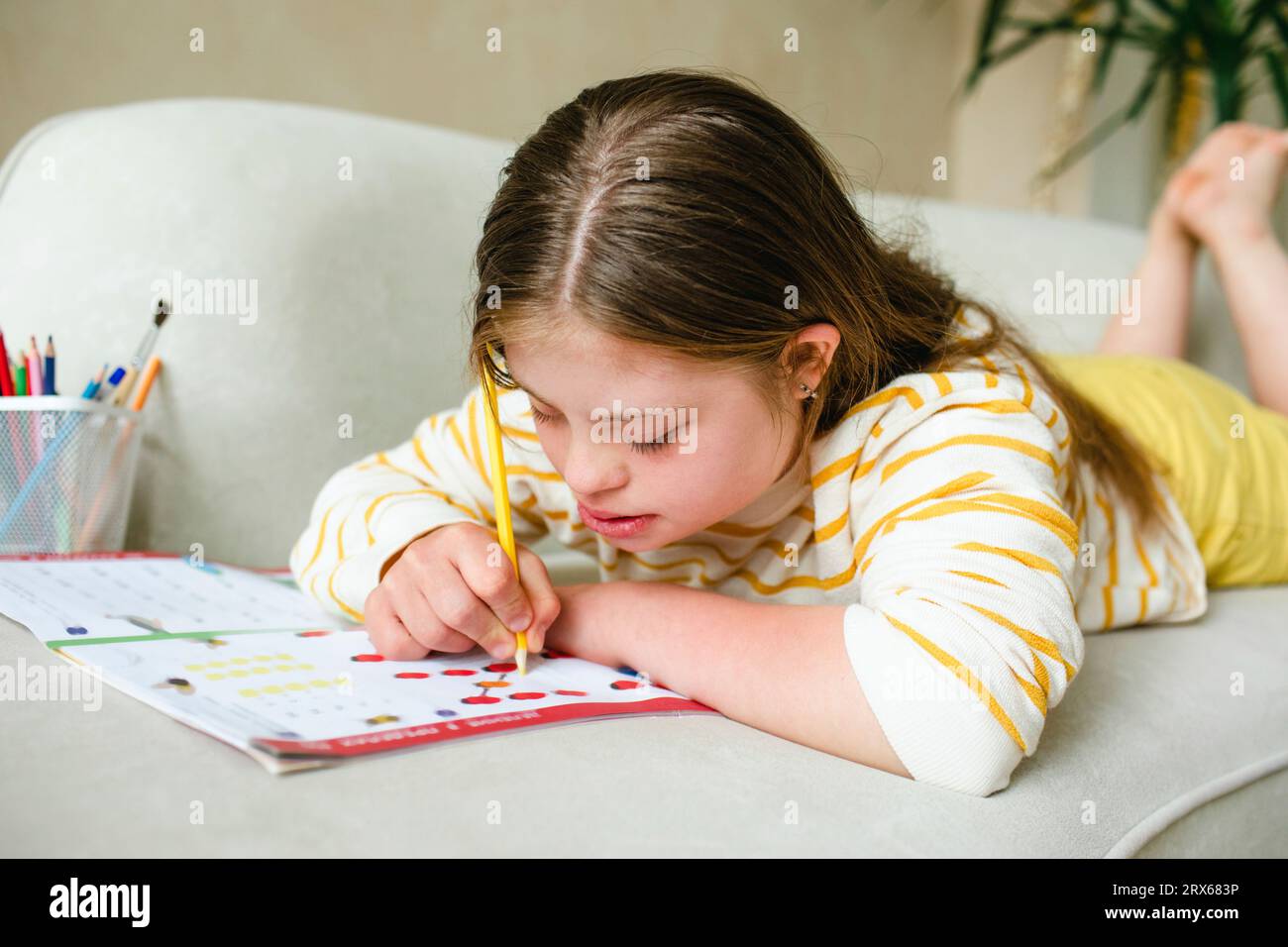 Teenage girl with down syndrome doing homework at home Stock Photo - Alamy