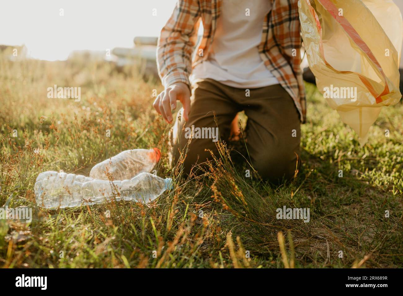 Boy collecting plastic bottles on grass Stock Photo - Alamy