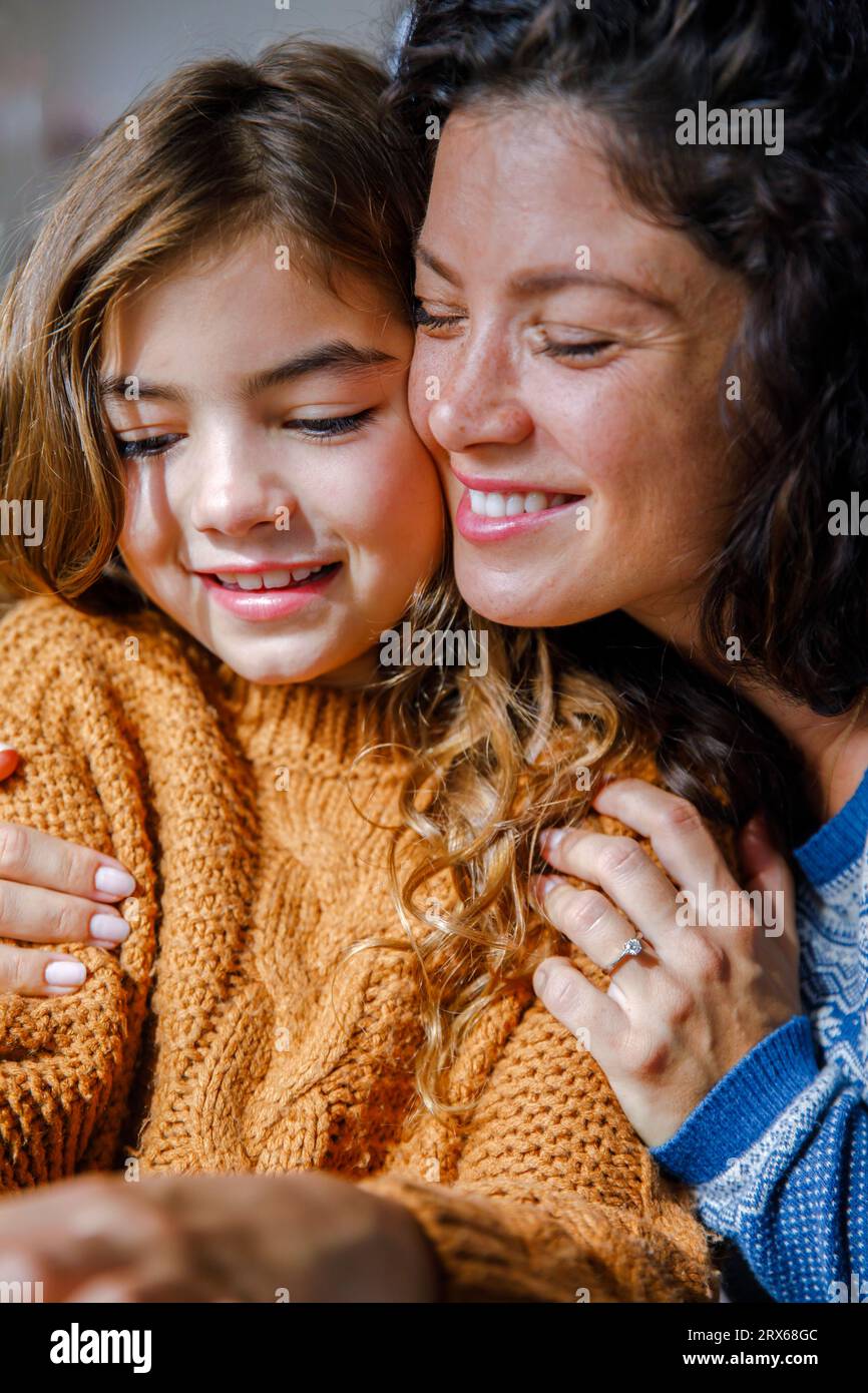 Smiling mother hugging daughter at home Stock Photo - Alamy