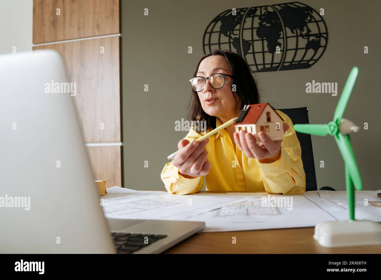 Engineer showing architectural model through video call at office Stock ...