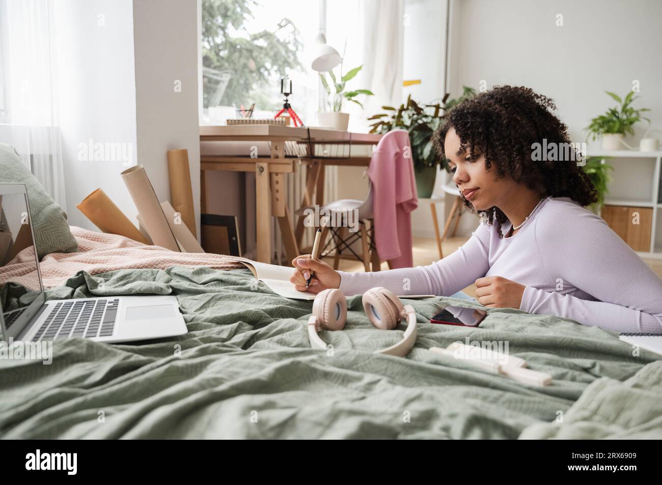 Curly haired girl doing homework at home Stock Photo - Alamy