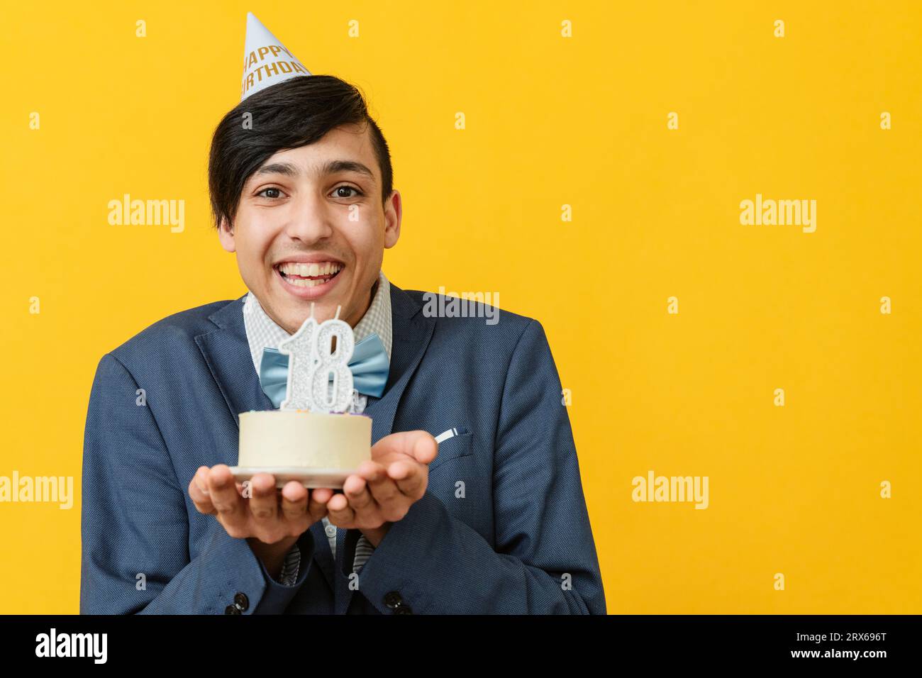 Cheerful man showing birthday cake at studio Stock Photo - Alamy