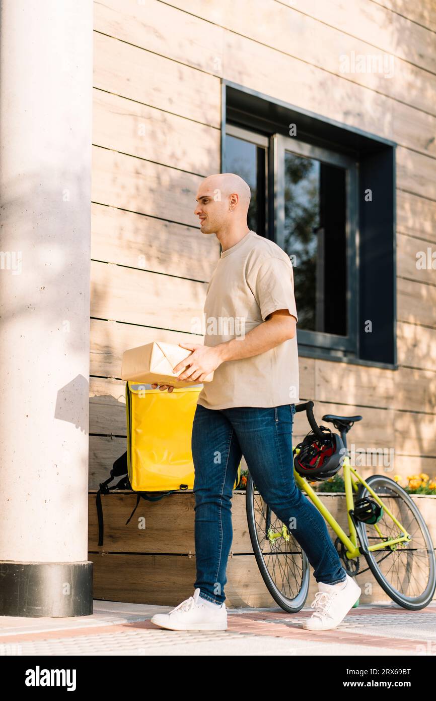 Male courier walking bicycle hi-res stock photography and images - Alamy