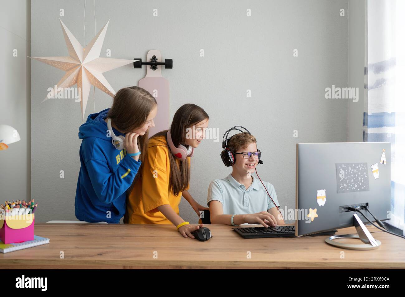 Smiling boy playing video game on computer by friends at home Stock ...