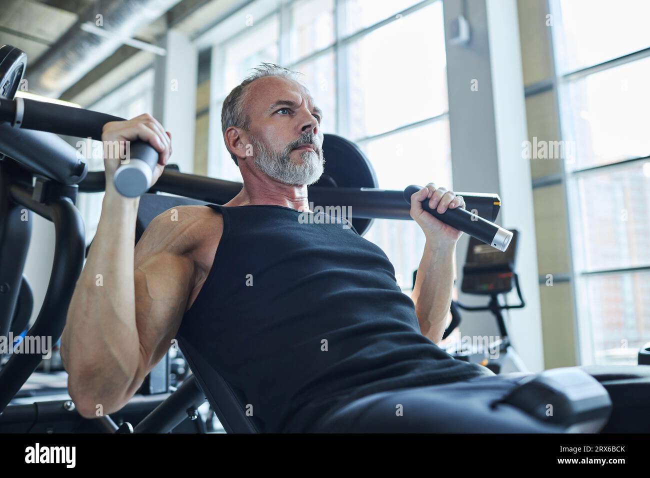 Contemplative man doing strengthening exercise in health club Stock ...