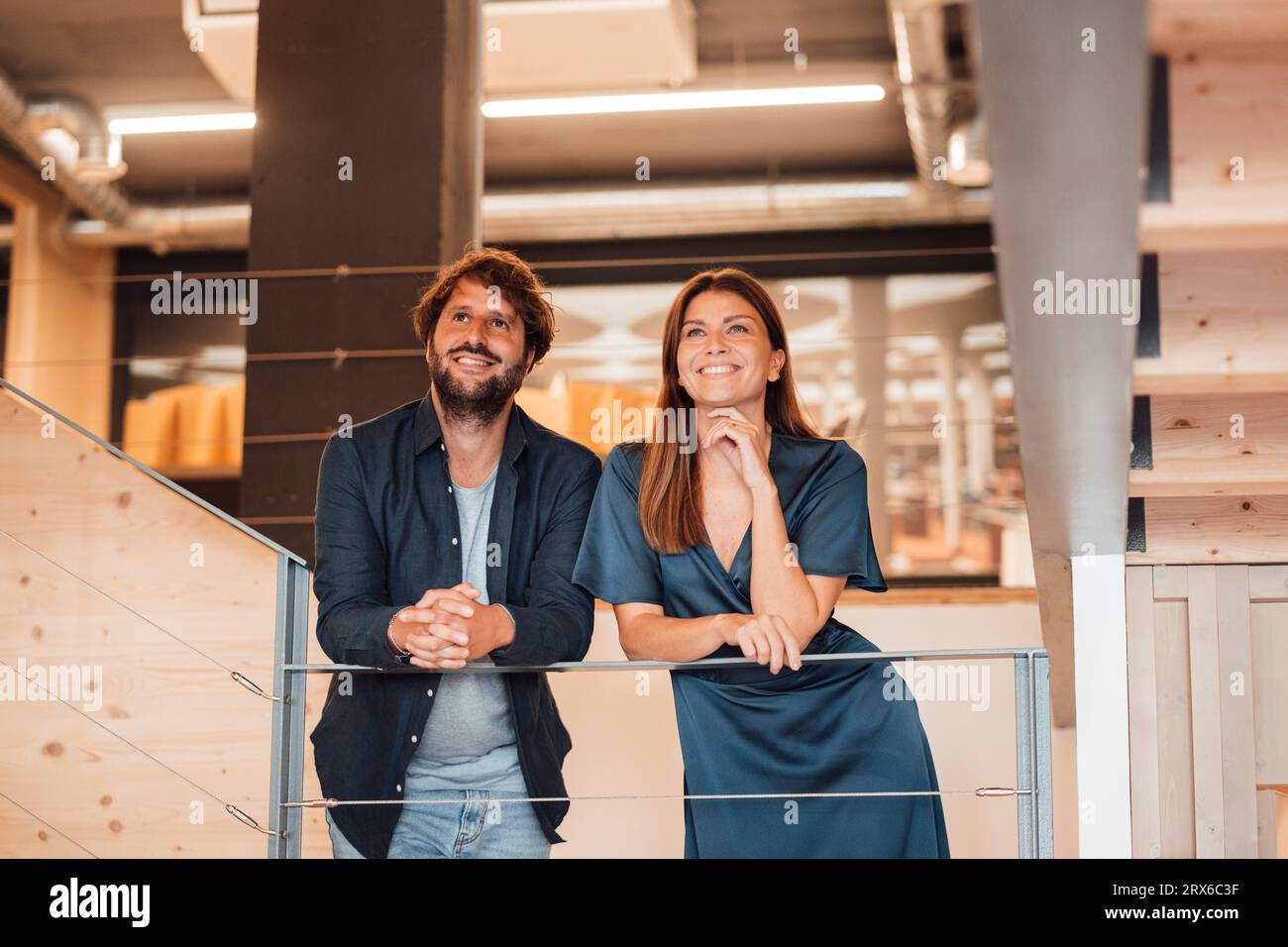 Thoughtful business people leaning on railing Stock Photo - Alamy