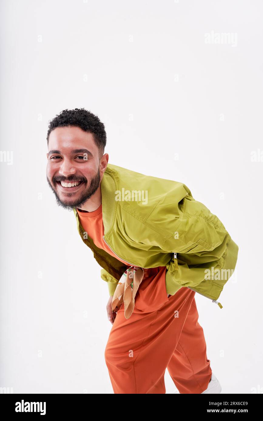 Smiling man bending against white background Stock Photo - Alamy