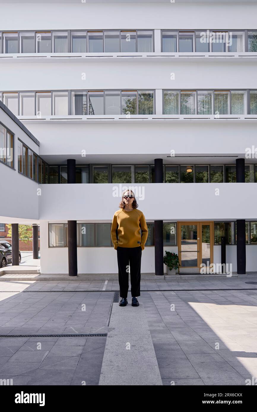 Man standing on bench in front of building Stock Photo - Alamy