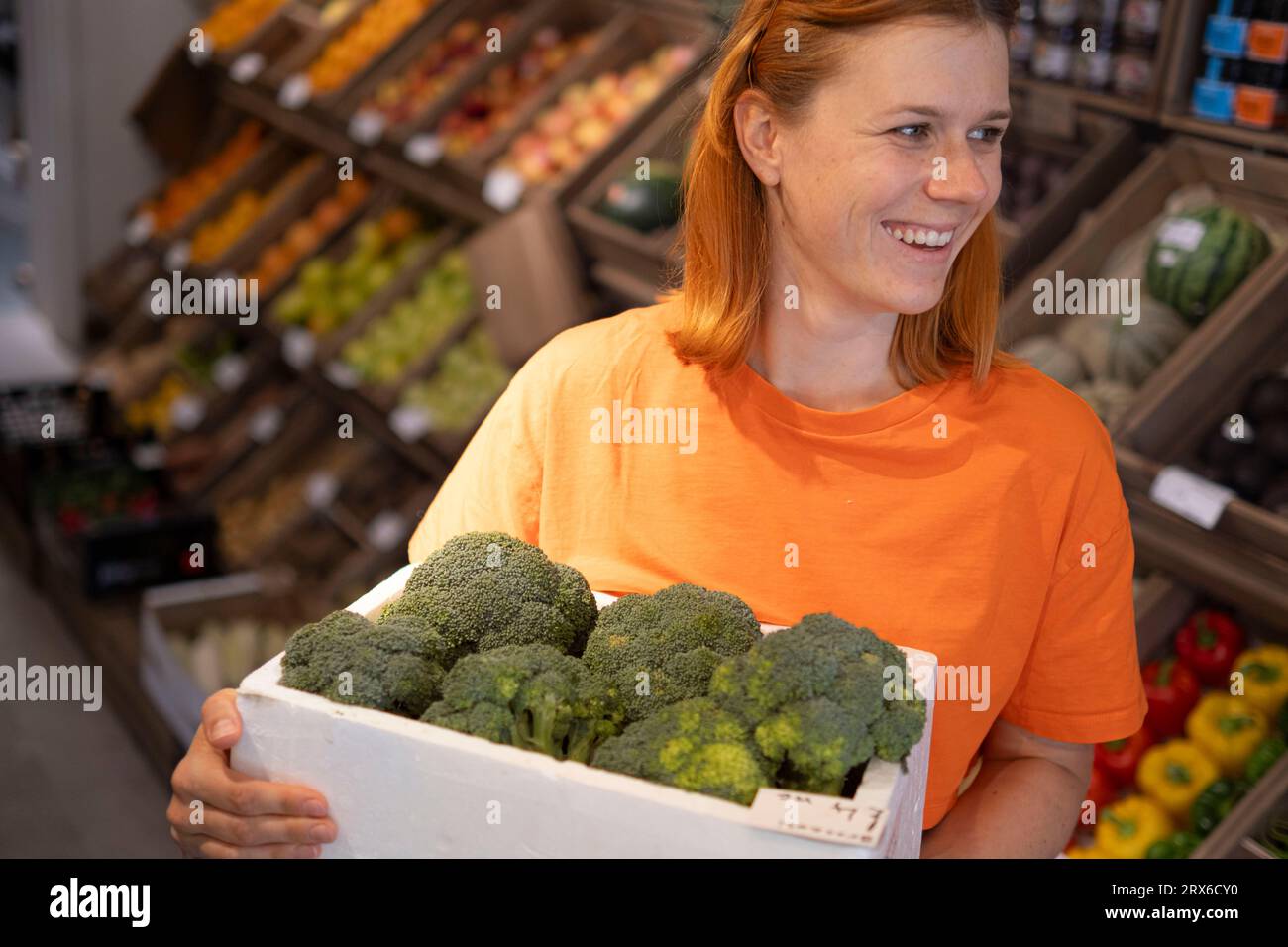 Happy woman with box of broccoli in supermarket Stock Photo - Alamy