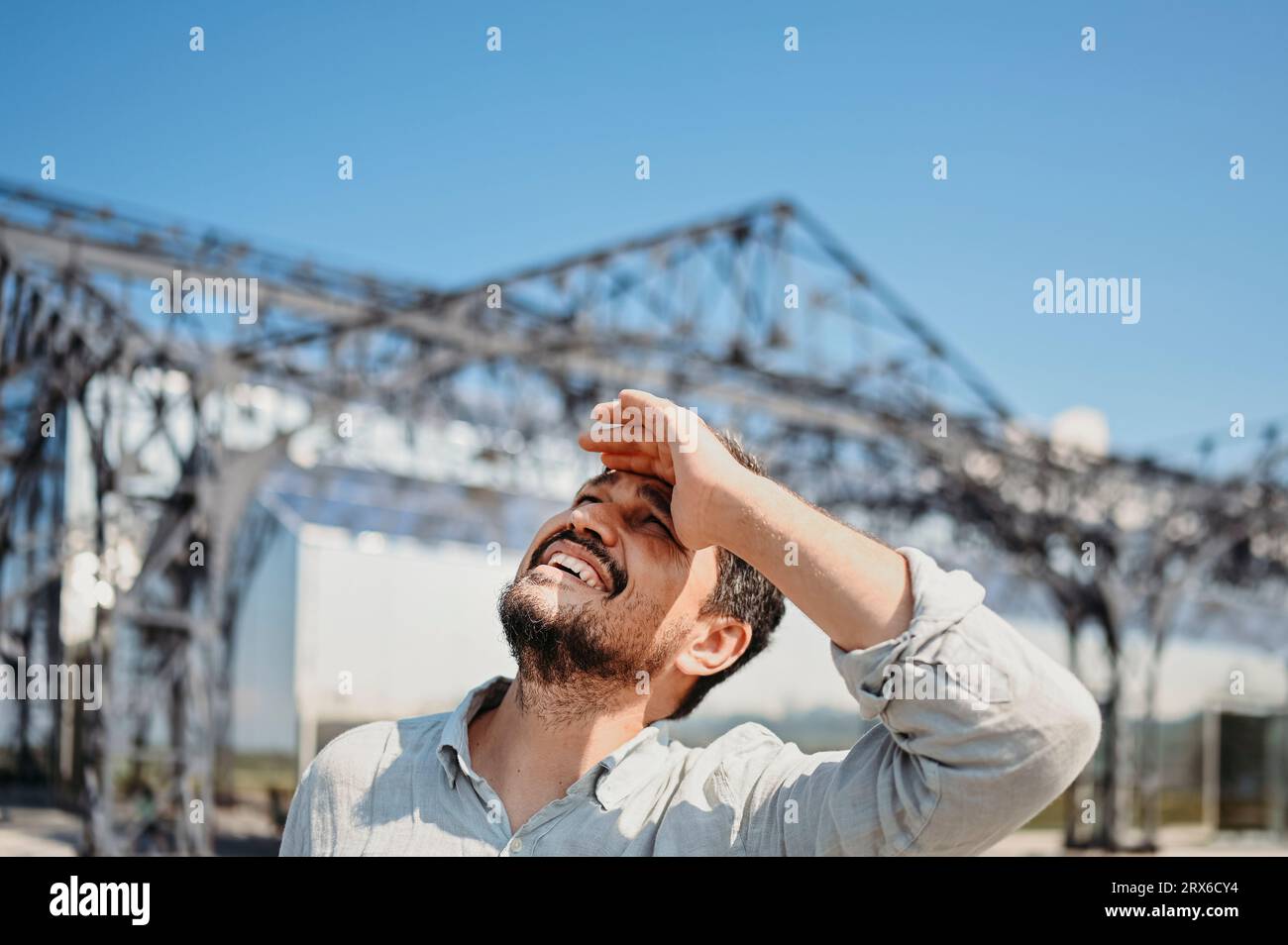 Man shielding eyes in front of building Stock Photo - Alamy