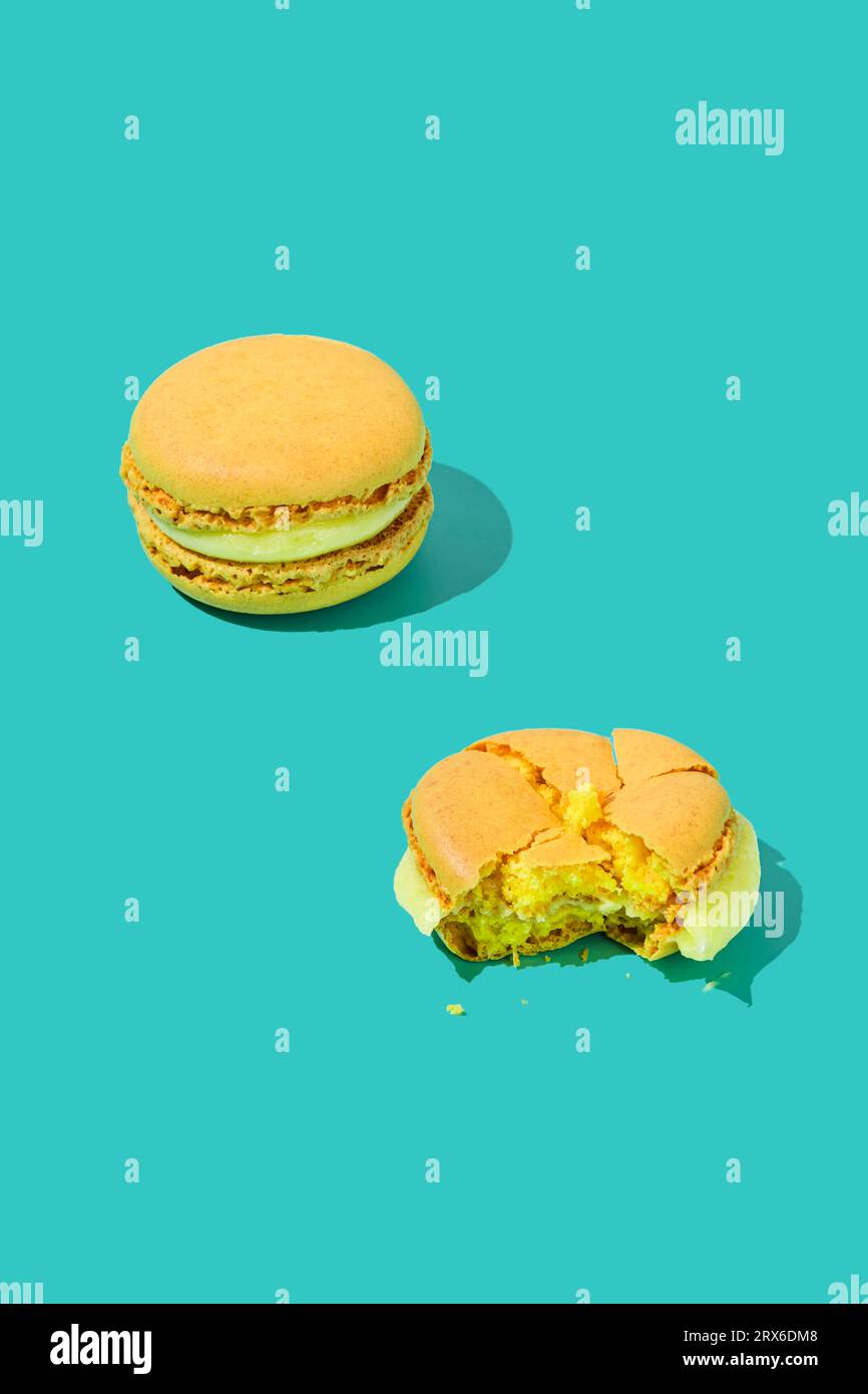 Crushed and full macaroon on turquoise background Stock Photo - Alamy