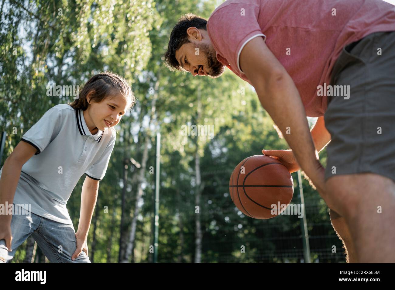 Father teaching son to dribble basketball Stock Photo - Alamy