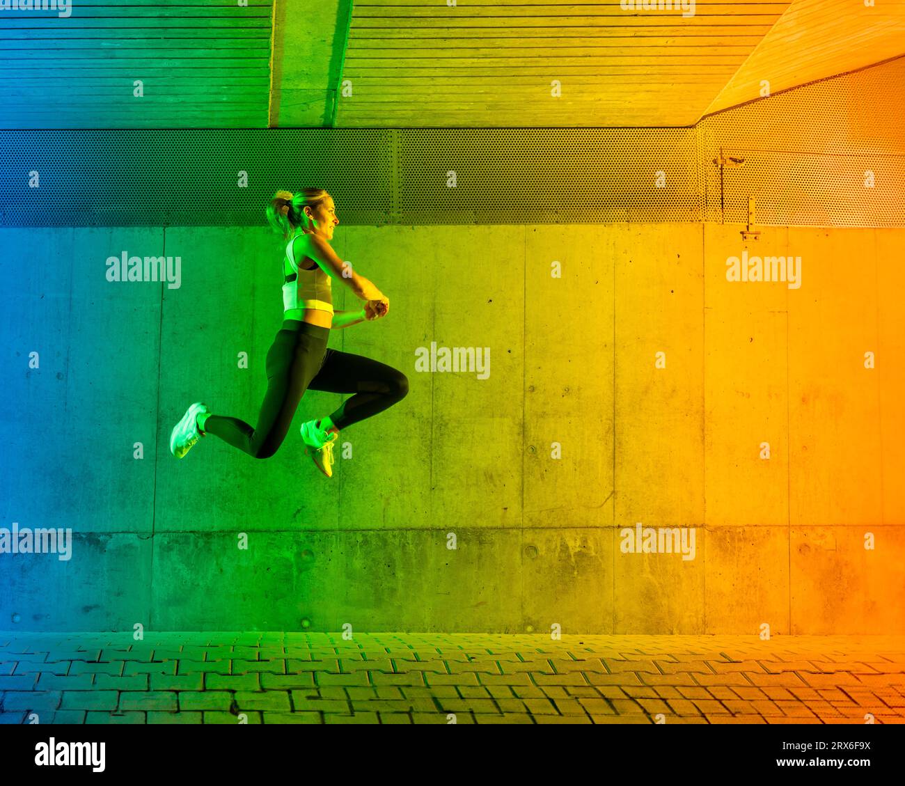 Woman jumping in front of wall Stock Photo - Alamy