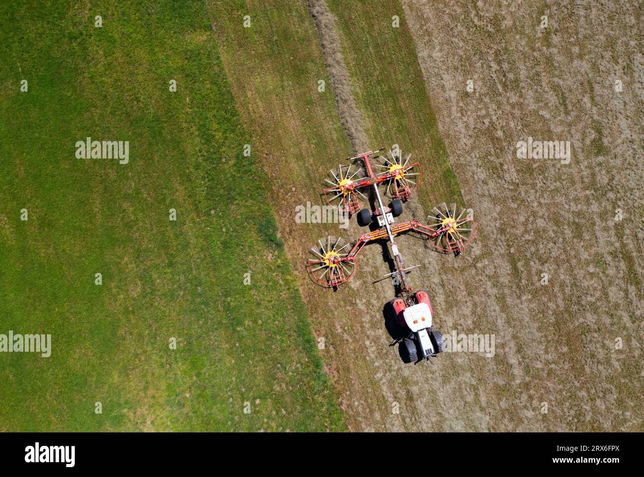 Drone view of tractor with rotary rakes turning hay Stock Photo - Alamy