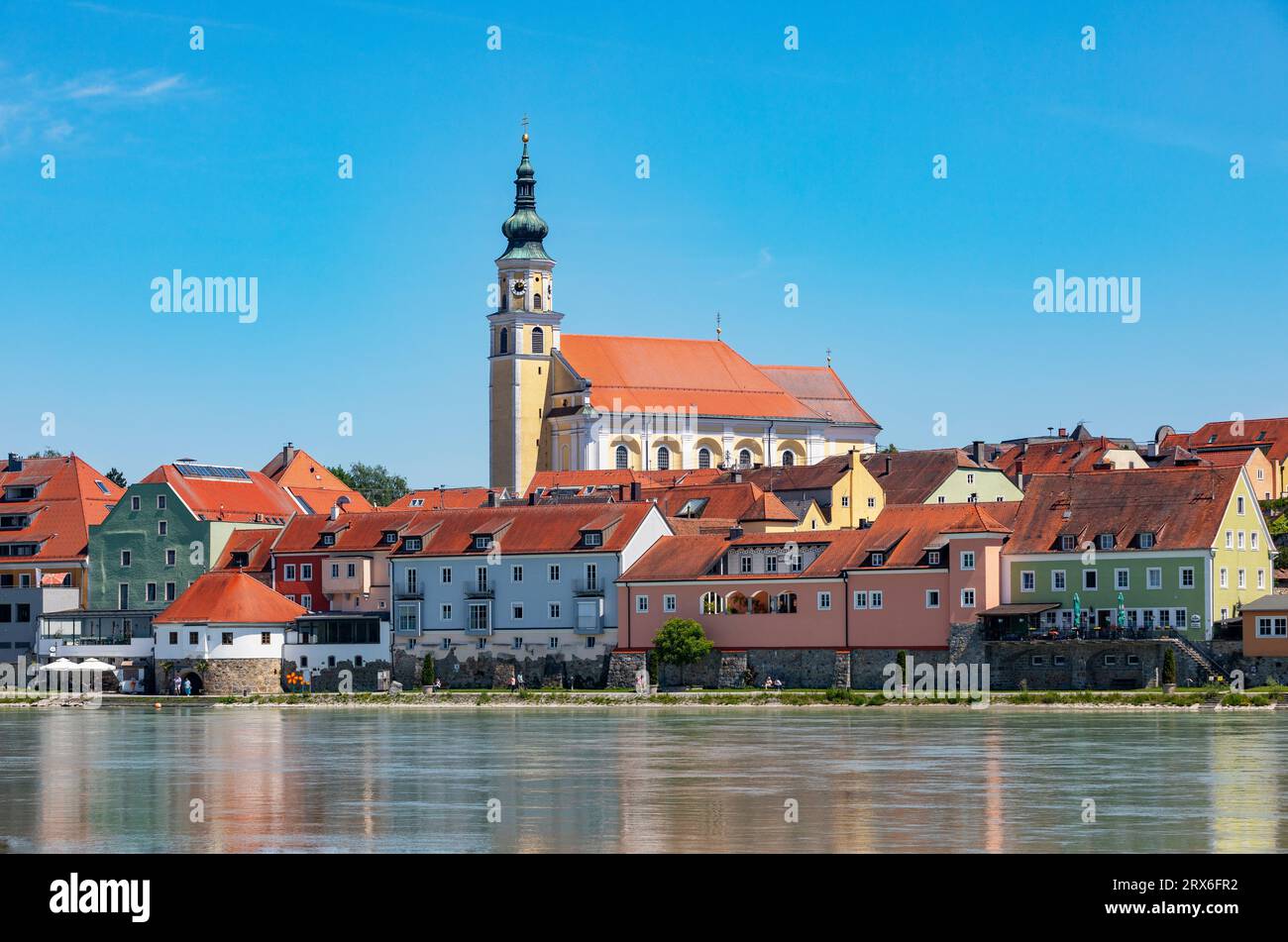 Austria, Upper Austria, Scharding, Houses along river Inn with parish ...