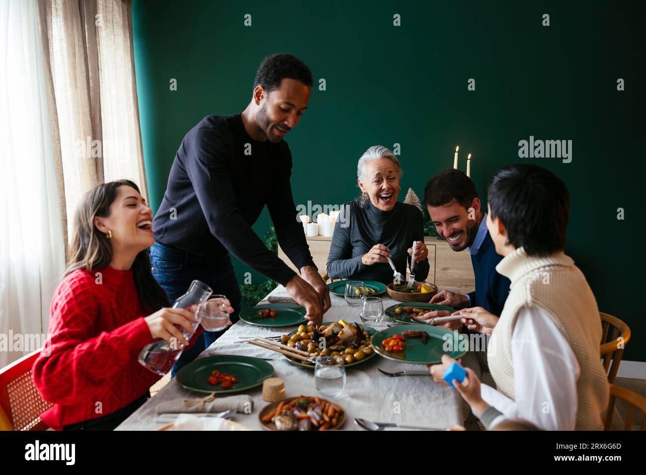 Multiracial family laughing and enjoying dinner at home Stock Photo - Alamy