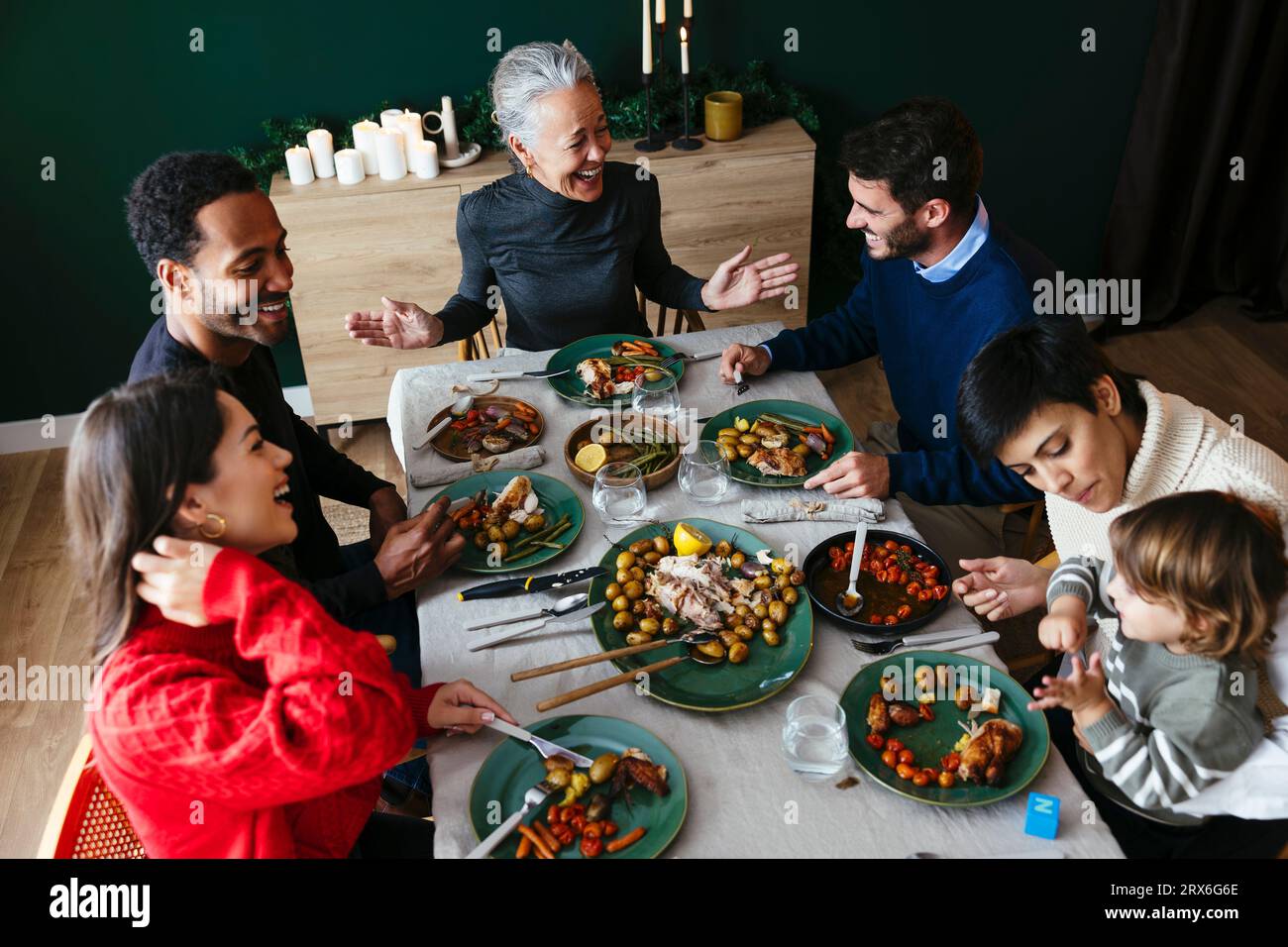 Cheerful multiracial family enjoying dinner party on Christmas Stock ...