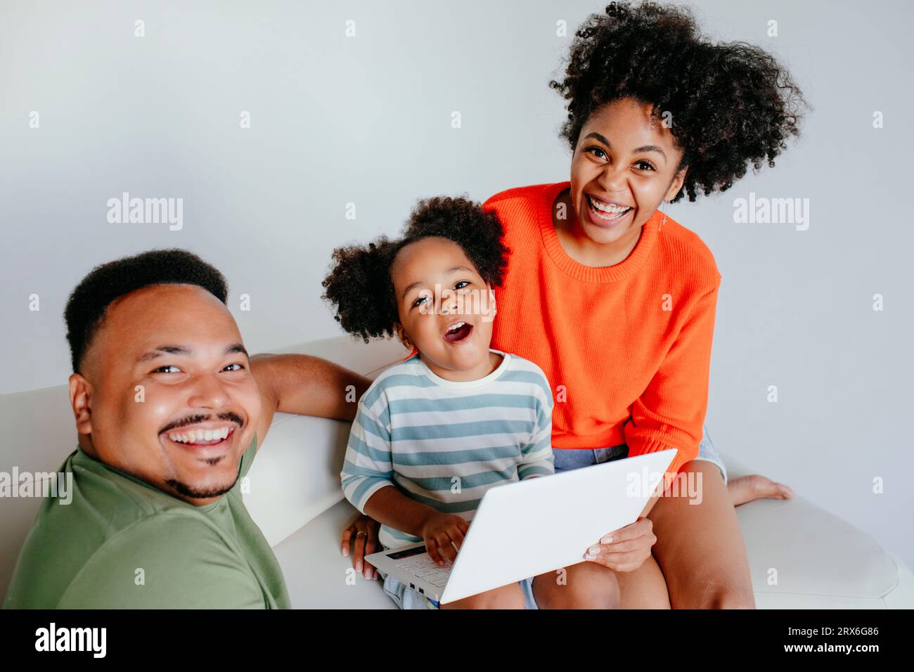 Happy family with laptop against white background in studio Stock Photo ...