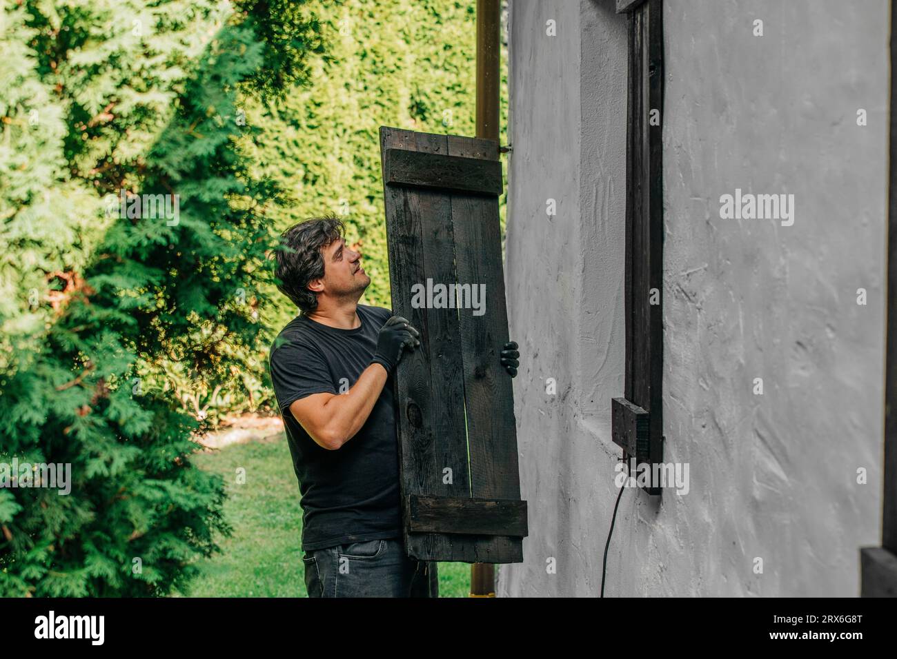 Man installing window of old house Stock Photo - Alamy