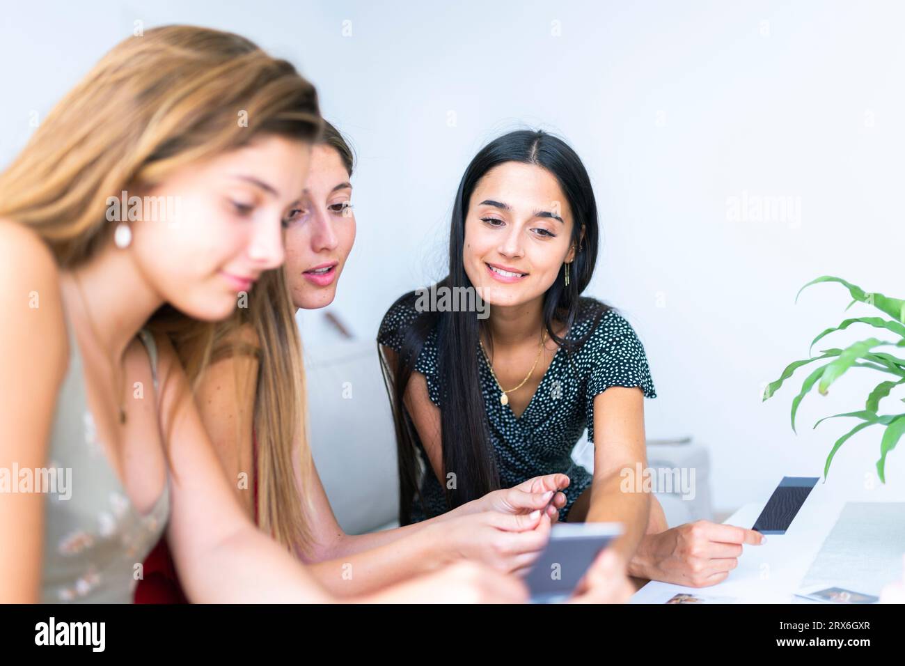 Smiling friends looking at photographs Stock Photo - Alamy